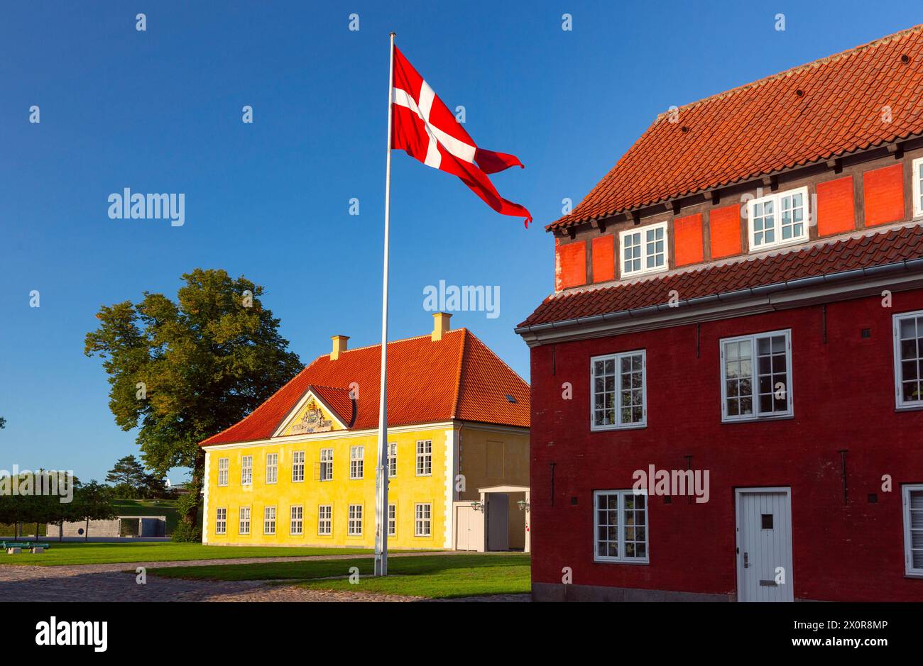 Danish flag waves over Royal Barracks at sunset in Copenhagen, Denmark ...