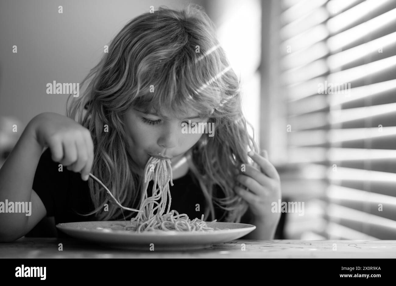 Tasty food, messy child eating spaghetti Close up portrait of funny kid ...