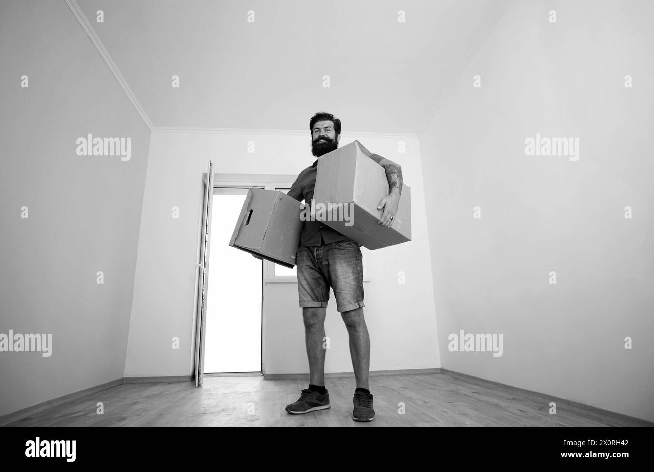 Man carrying cardboard box on moving day. Delivery man loading ...