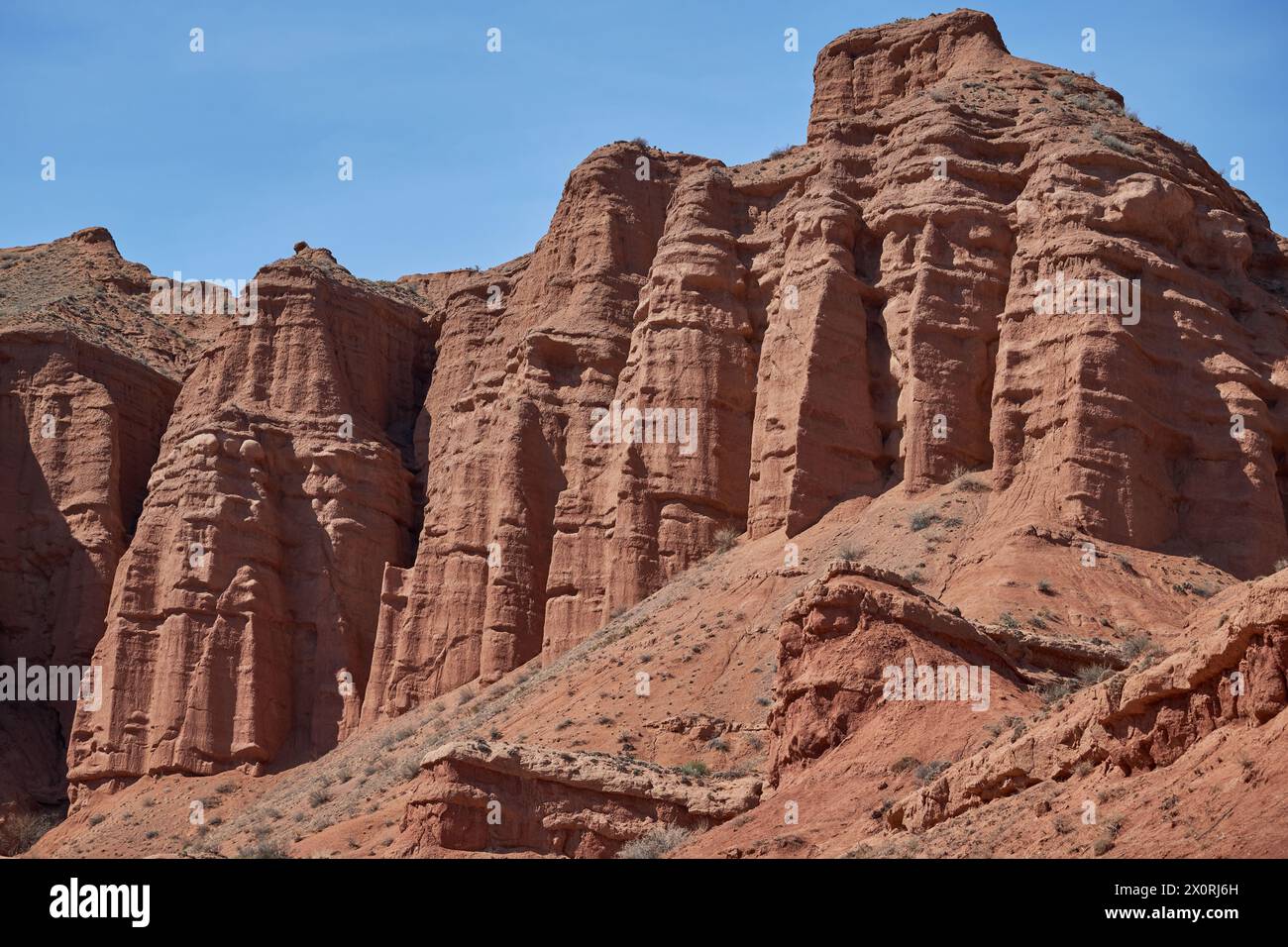 Sheer cliffs subject to erosion, red rocks of the Konorchek canyon ...