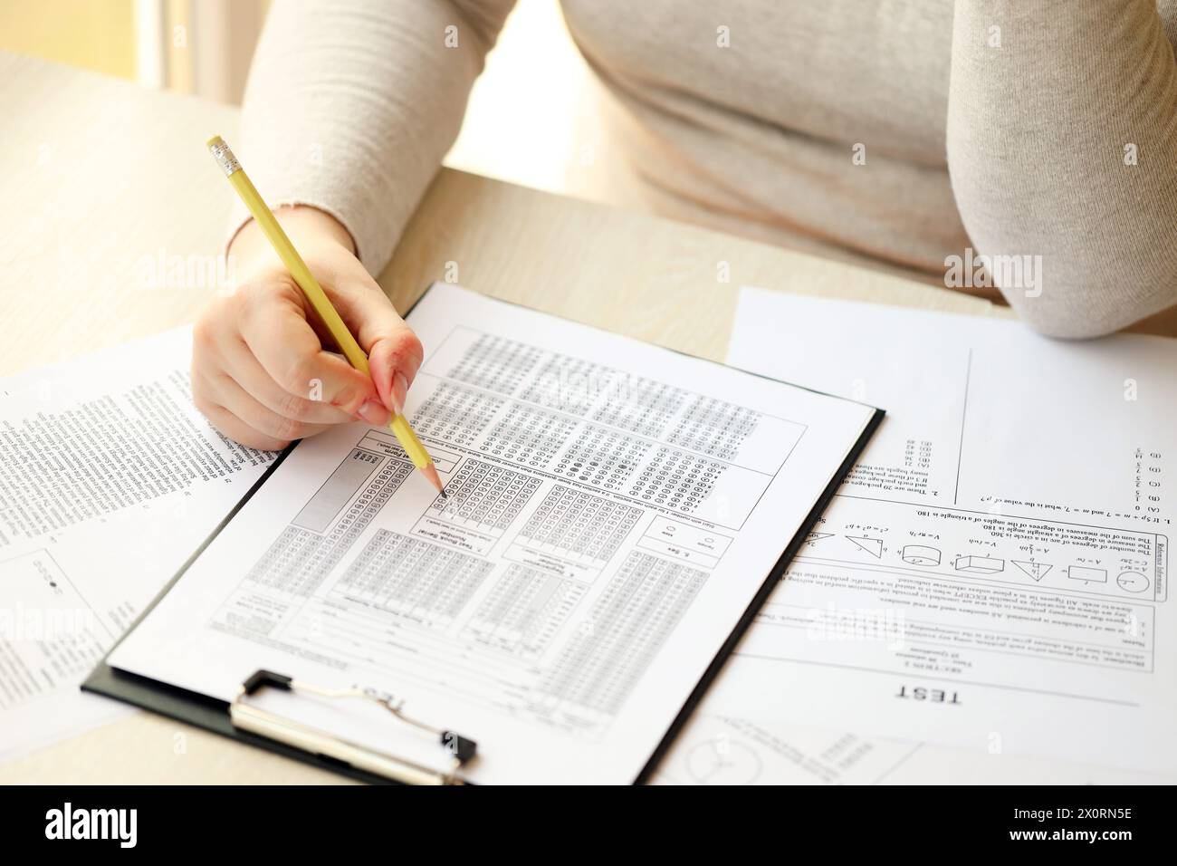 Female student hands testing in exercise and taking fill in exam paper ...