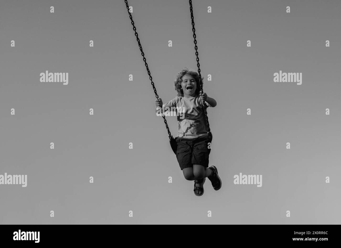 Joyful kid swinging on a swing. Happiness children. Child extreme swinging. Danger high Swing in ...