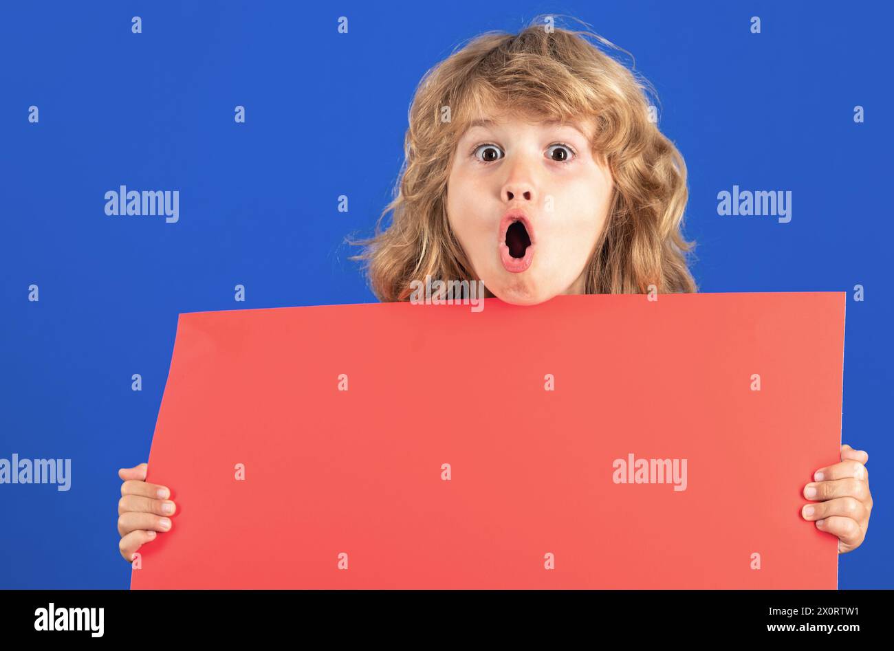 Excited portrait of funny smiling child with red blank banner on studio ...