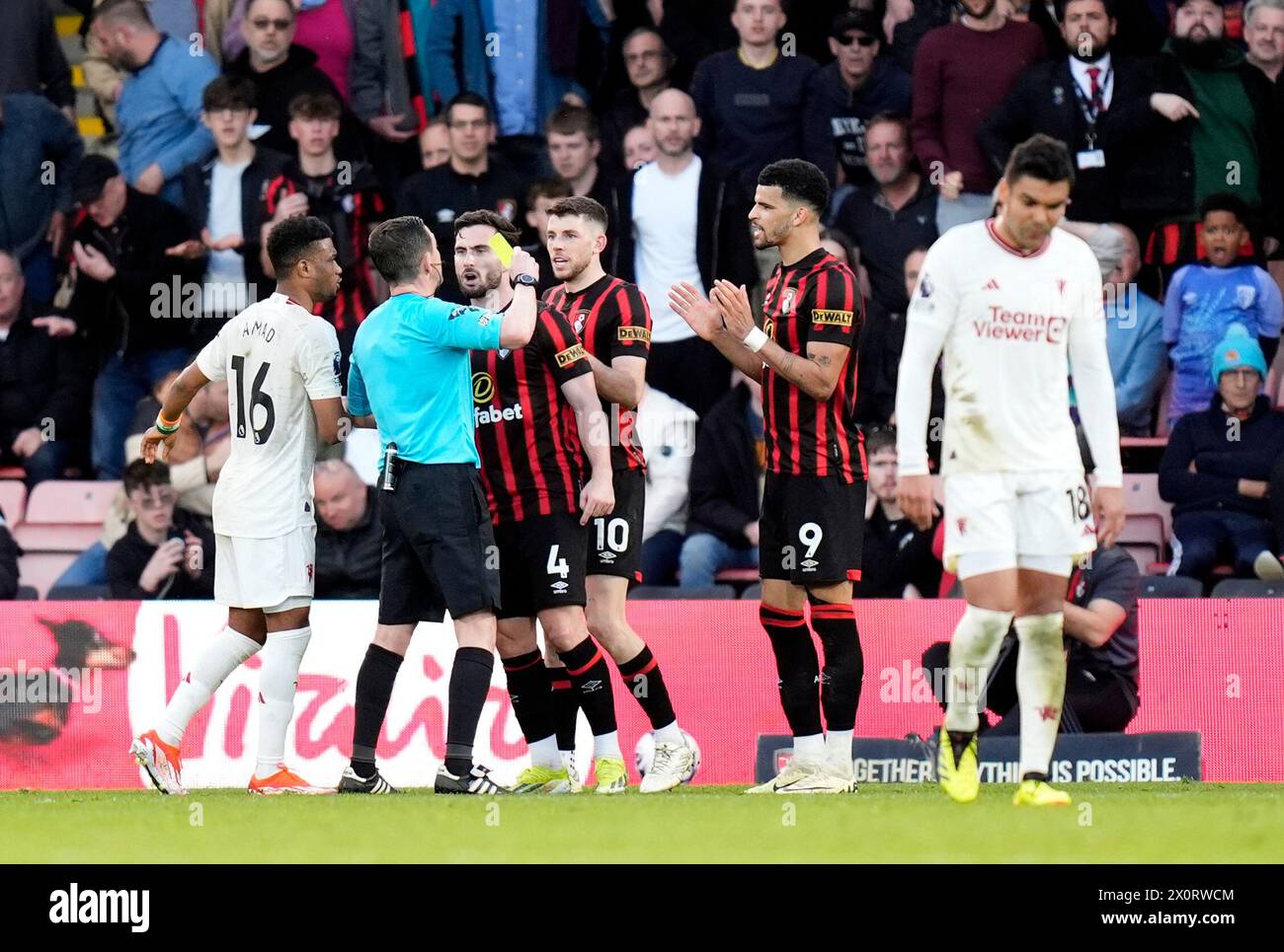 Referee Tony Harrington shows a yellow card to Bournemouth's Lewis Cook ...
