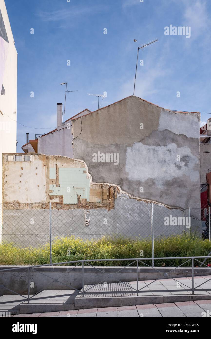 Urban scene with an undeveloped plot of land where the remains of an ...