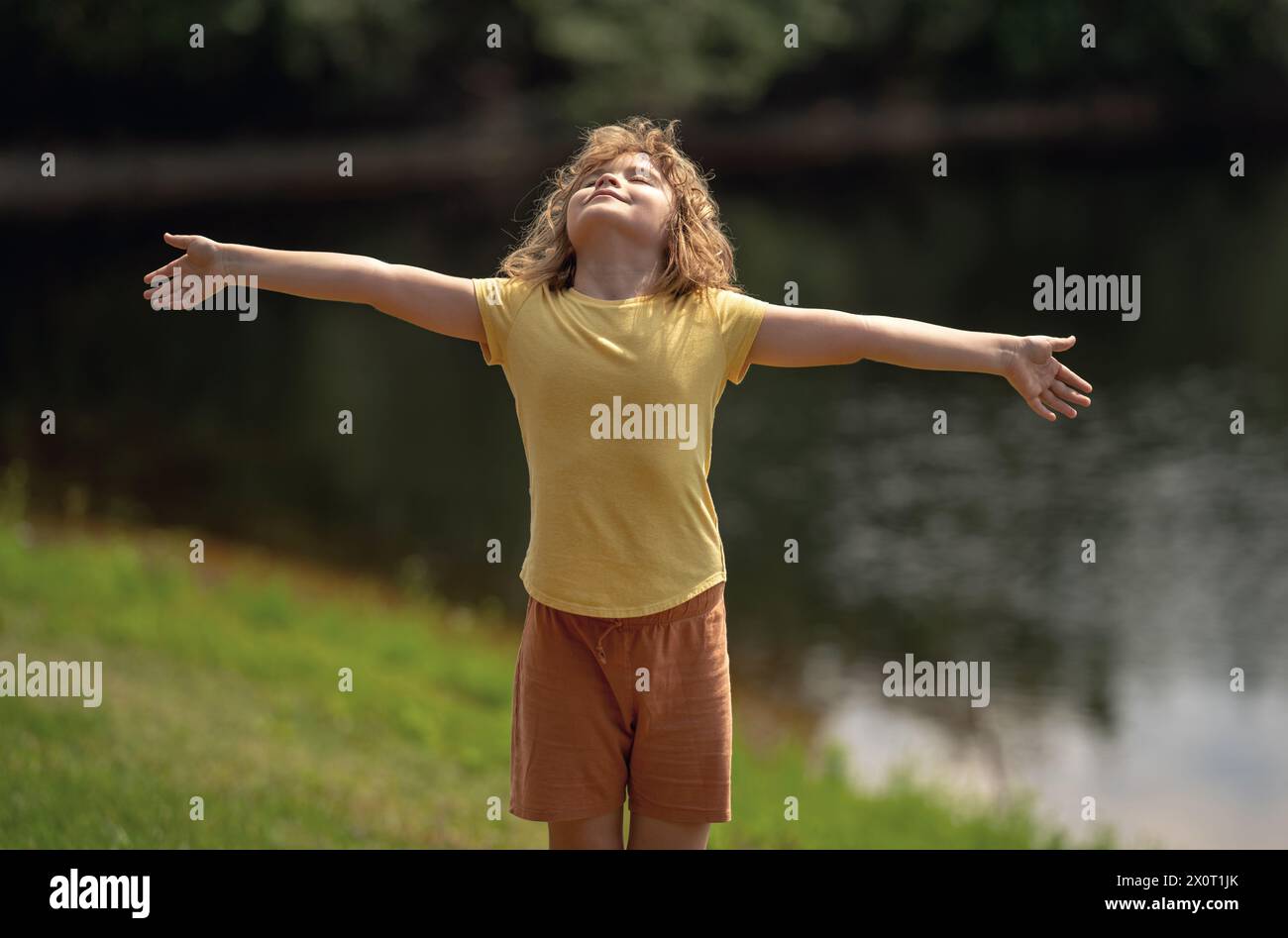 Happy kid with arms up enjoying freedom in nature. Child open arms ...
