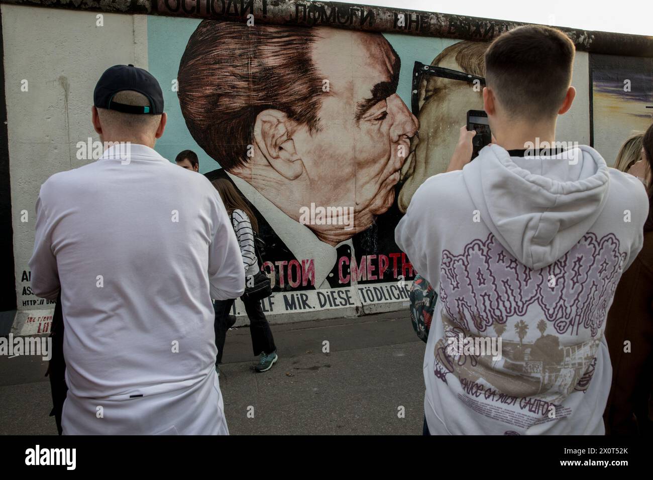 Onlookers observe and capture photos of the iconic Socialist Fraternal ...