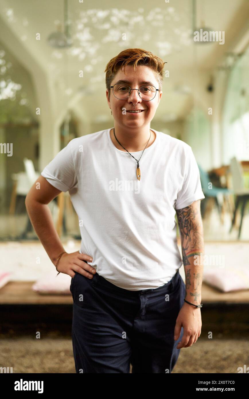 Smiling Gen Z transgender pro stands in modern office, casual style ...