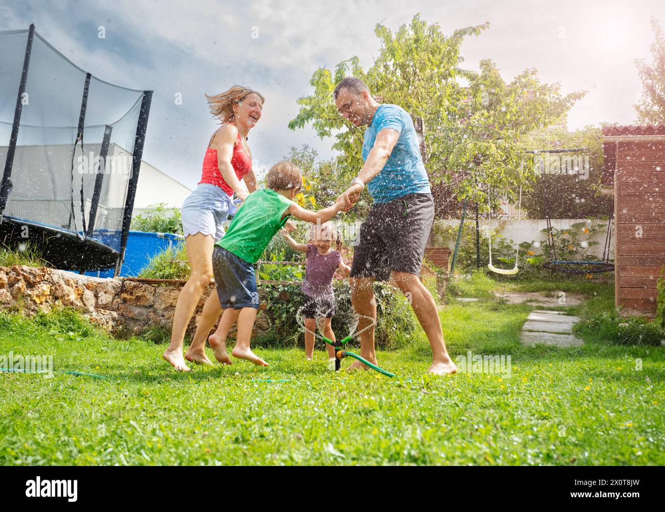 Girl running through sprinkler hi-res stock photography and images - Alamy