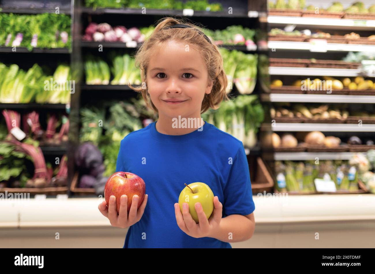 Kid with apple fruits at grocery store. Little child choosing food in ...