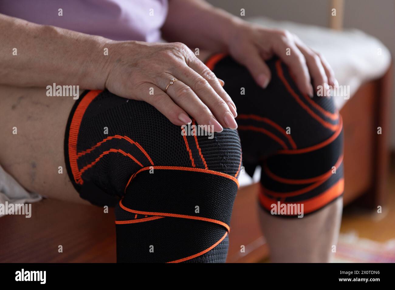 Old hands on knees, legs in knee pads, elderly man with sore arms and ...