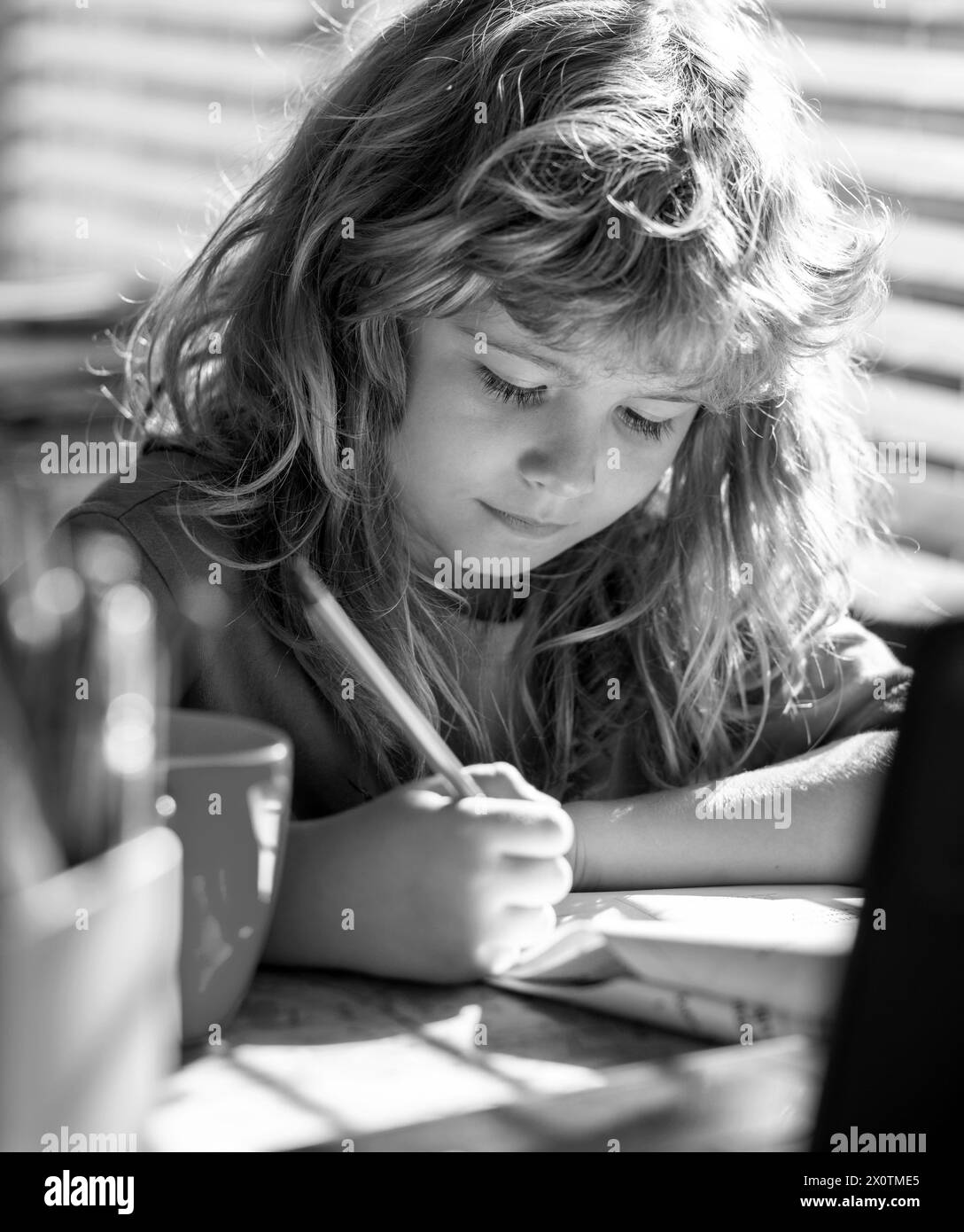 Child writing homework in school class. Kid boy at home writes draws ...