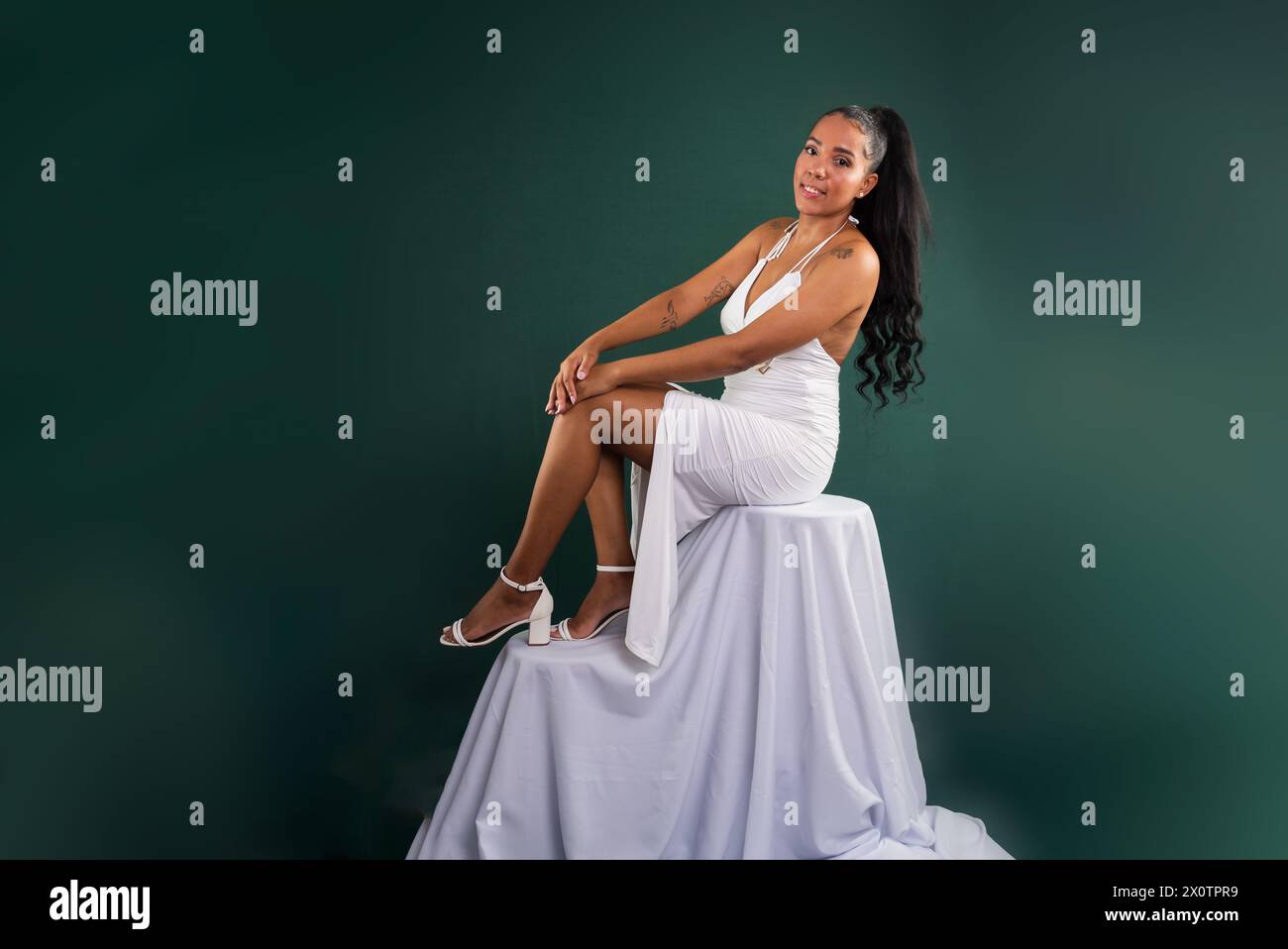 Beautiful brunette woman sitting with hands on her knees posing for ...