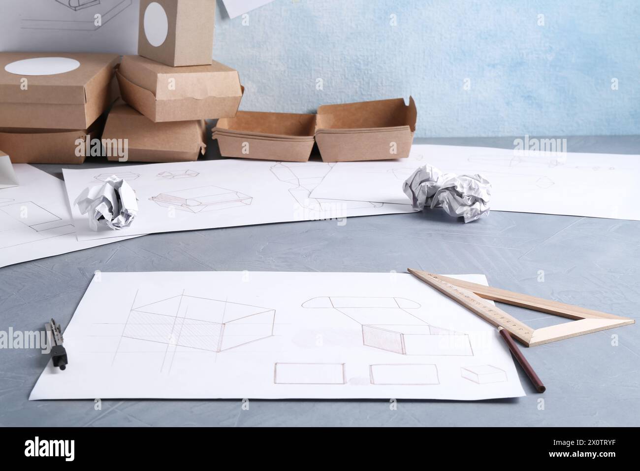 Creating packaging design. Drawings, boxes and stationery on blue ...