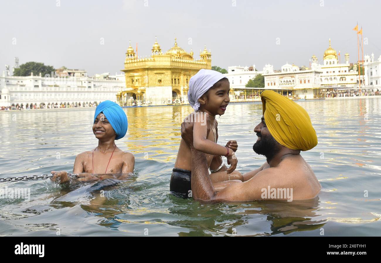 AMRITSAR, INDIA - APRIL 13: Sikh devotees take a dip in the holy ...