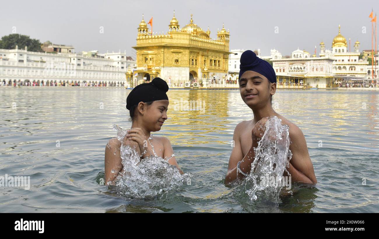 AMRITSAR, INDIA - APRIL 13: Sikh devotees take a dip in the holy ...