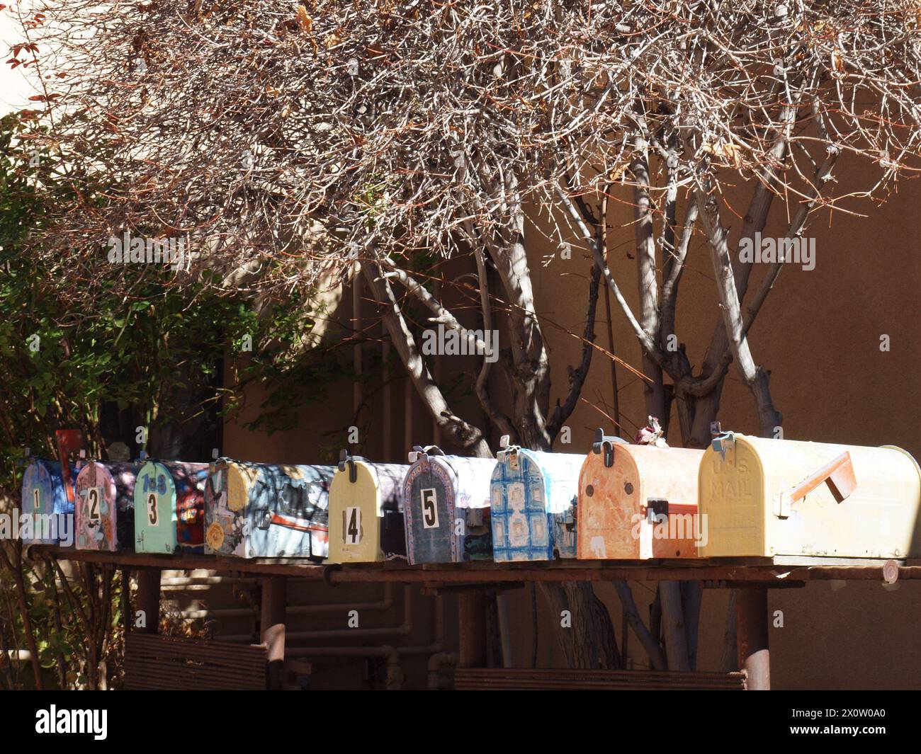 Large tree behind row of many colored mailboxes Stock Photo - Alamy