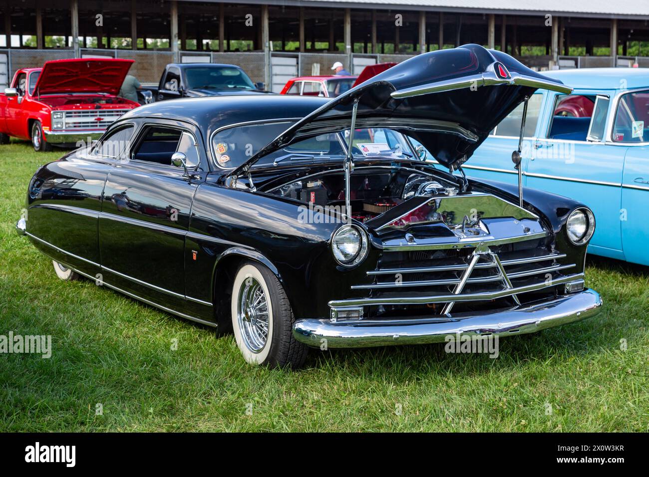 A modified black 1950 Hudson lead sled on display in a car show at the ...
