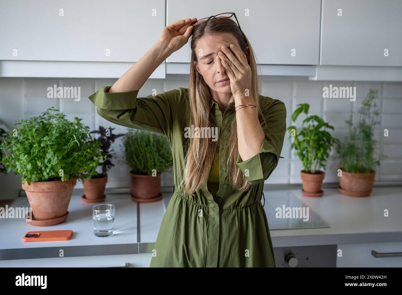 Sleepy tired woman suffering from insomnia rubbing eyes on kitchen with ...