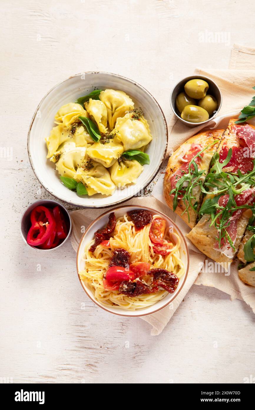 Full table of italian meals on plates pizza, pasta, ravioli, salad and ...