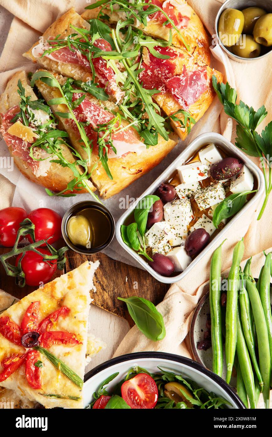 Full table of italian meals on plates pizza, pasta, ravioli, salad and ...
