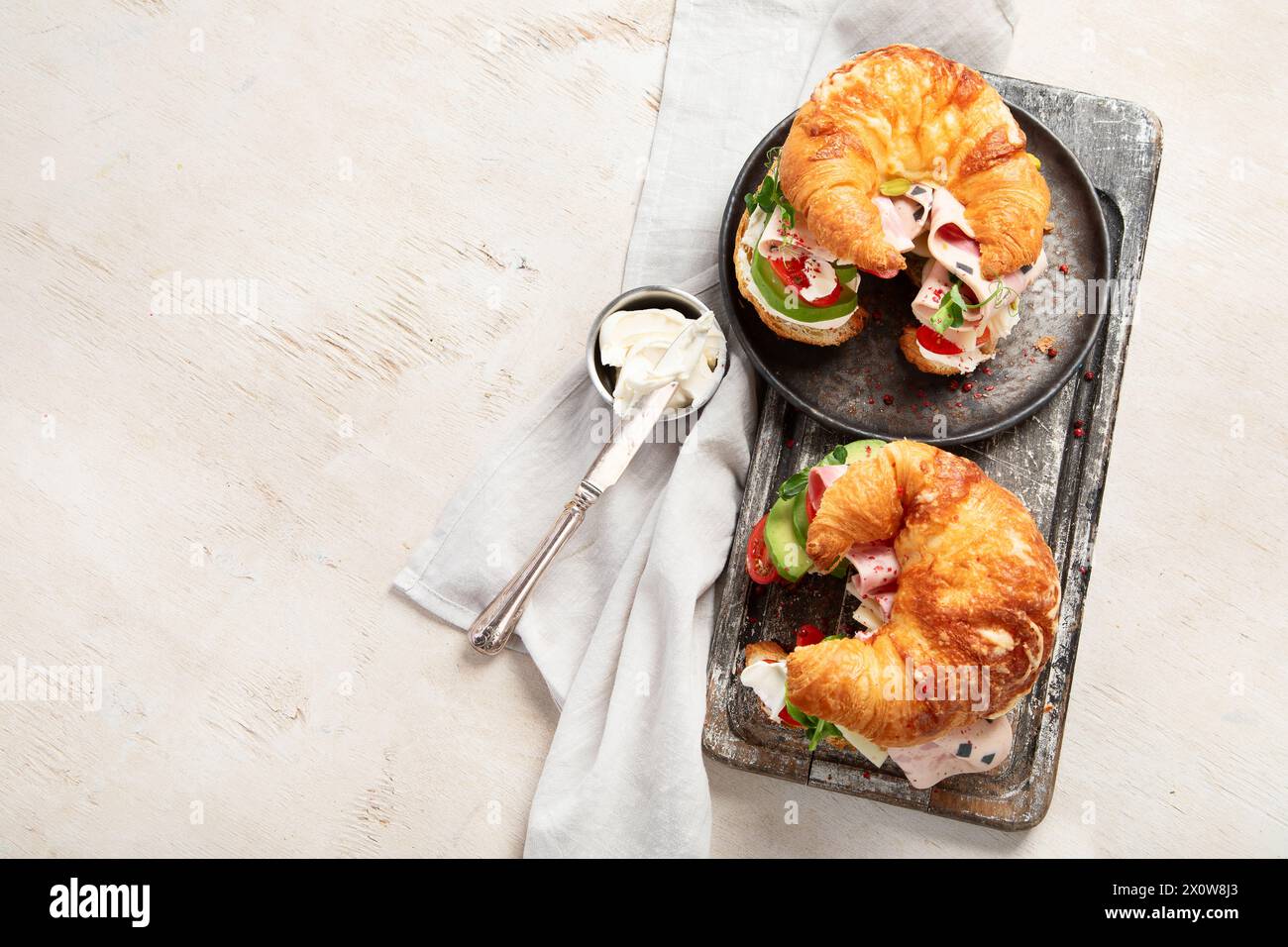 Salted healthy breakfast on light background. Fresh sandwich with croissant bun, cream cheese ...