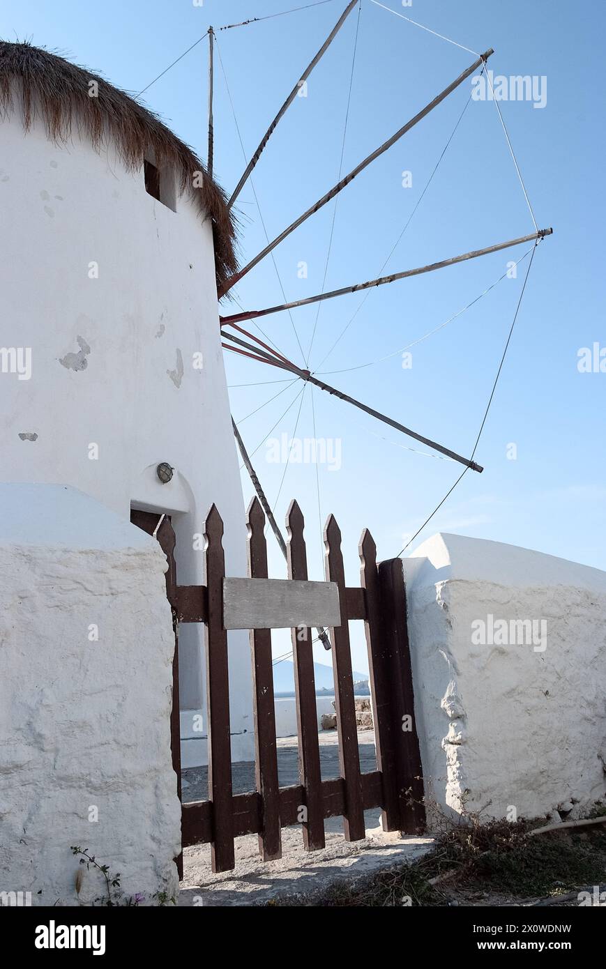A close-up of a classic Greek windmill's thatched roof and wooden gate ...