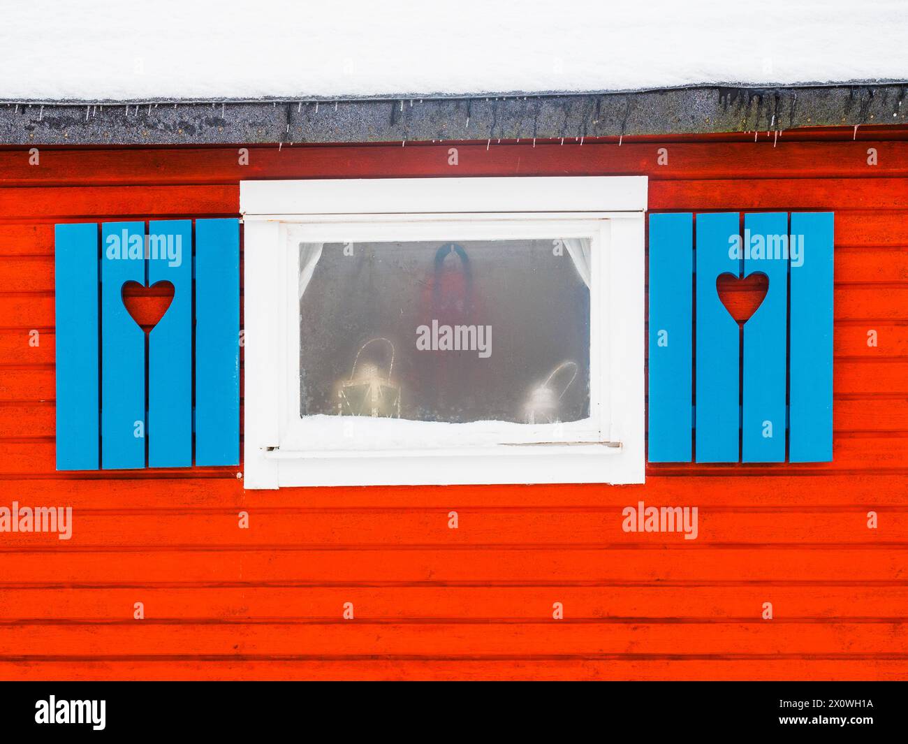A charming red wooden facade of a typical Swedish house is adorned with ...