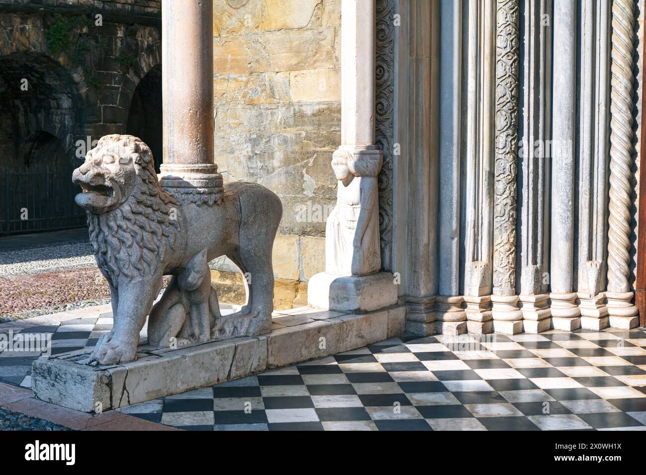 Lion statue in the courtyard of the Cathedral, marble columns ...