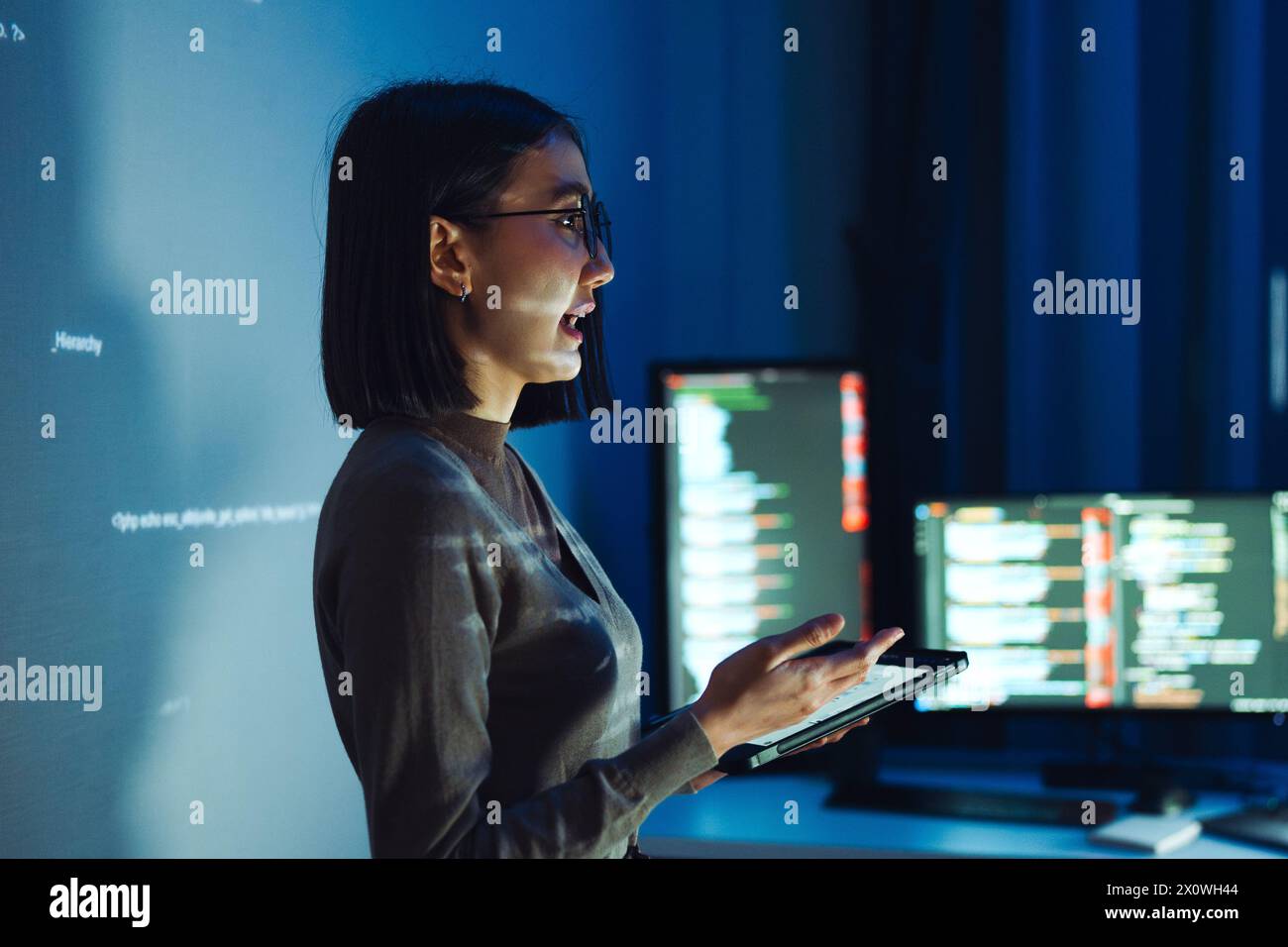 asian woman developer presentation about coding software data with devops team at night in ...