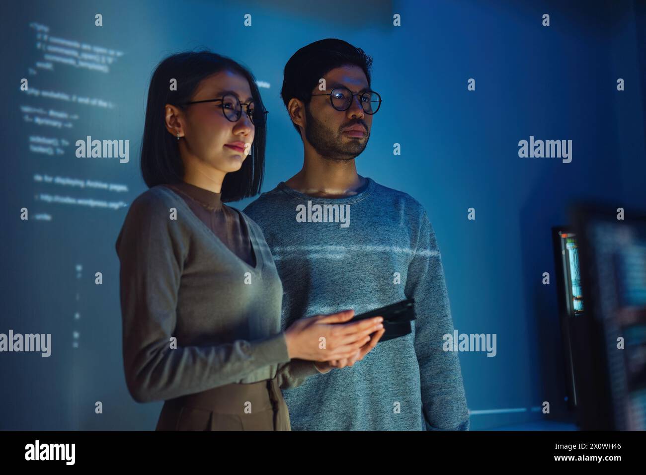 Two Asian And Indian Developer Presentation About Coding Software Data With Devops Team At Night