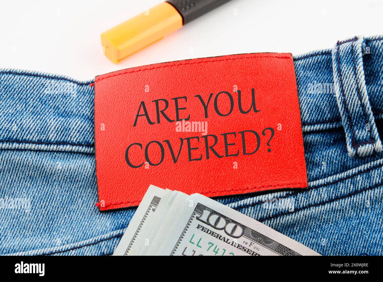 ARE YOU COVERED text written on the leather insert of jeans with dollar ...