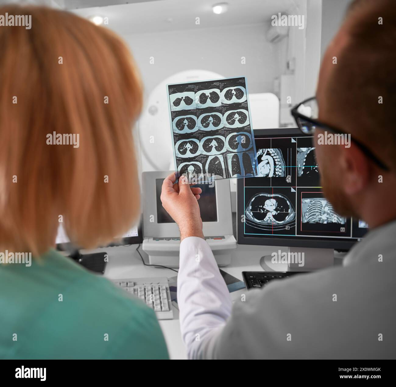 Medical computed tomography or MRI scanner. Back view of doctor and ...