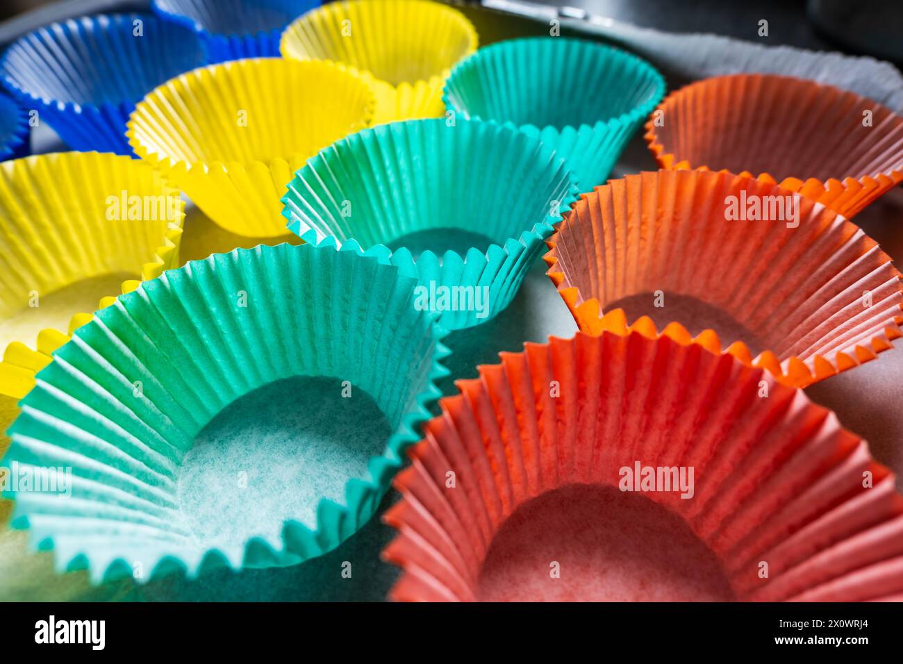 A vibrant display of baking cups in shades of green, light blue, and ...
