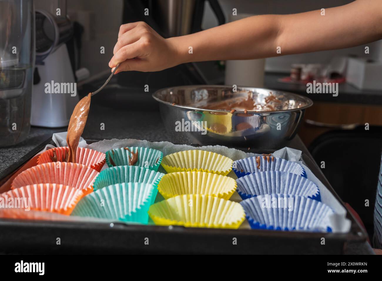 Child hands adding cupcake mix into colorful baking liners Stock Photo ...