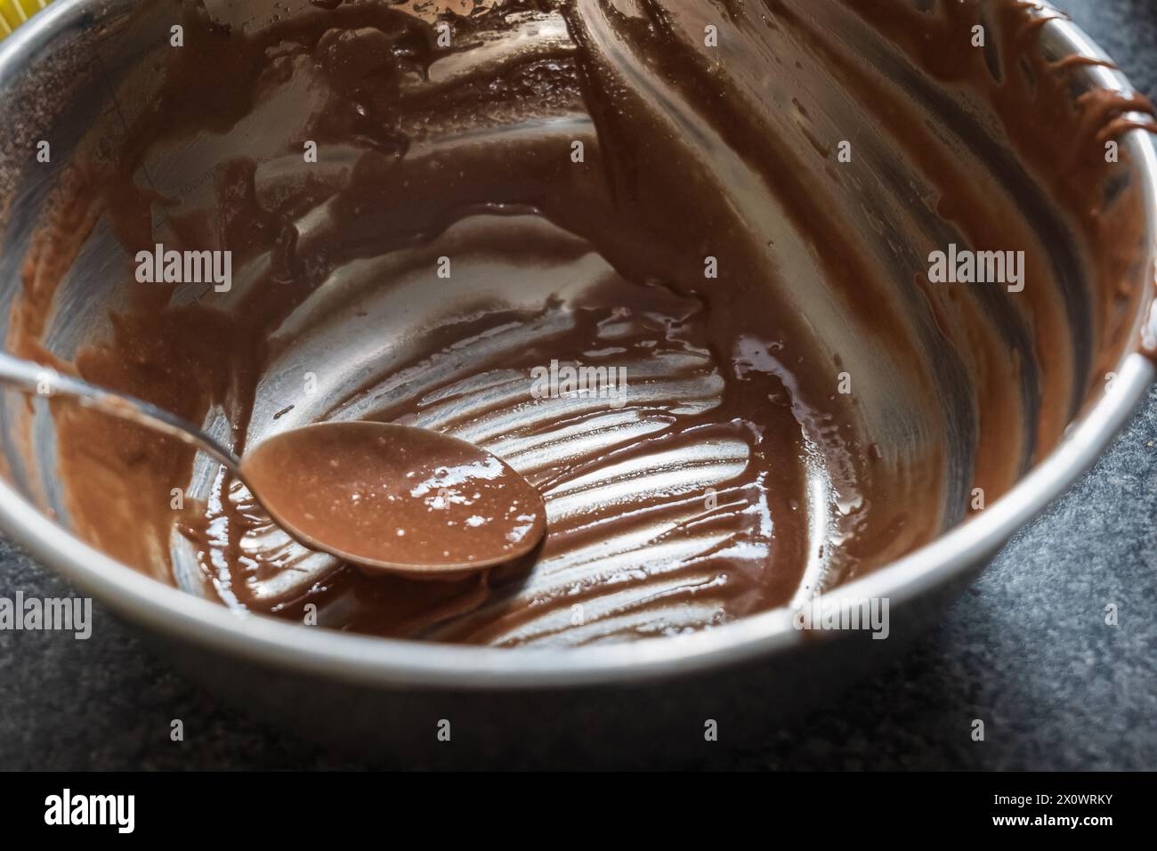 Dirty metal mixing bowl being used to prepare chocolate cupcakes with ...