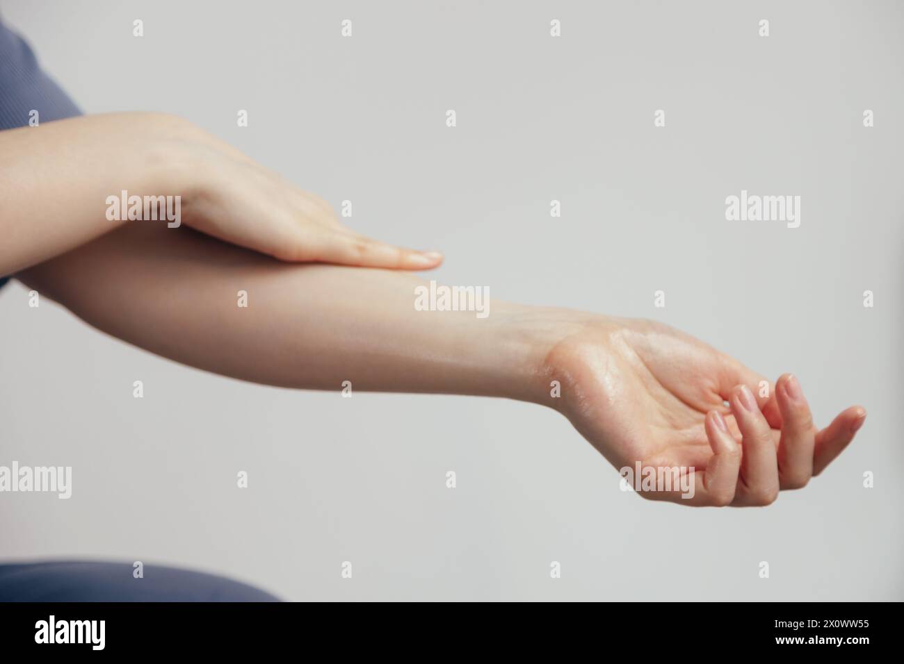 The woman is making a gesture by touching her arm with her hand Stock ...