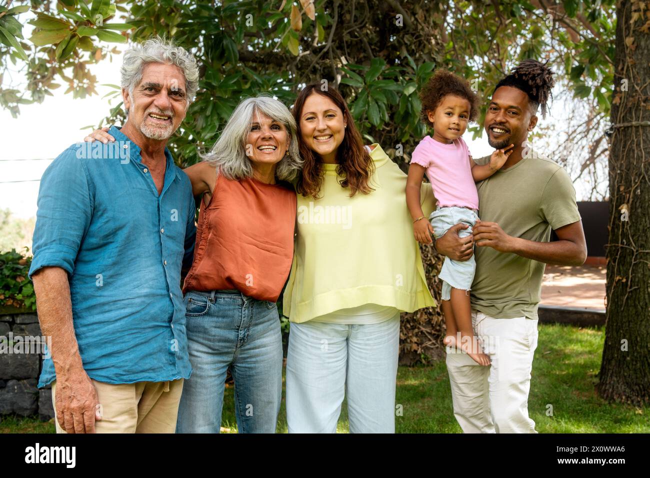 Diverse, multigenerational family portrait - moment of affection - Grandparents beam with joy ...