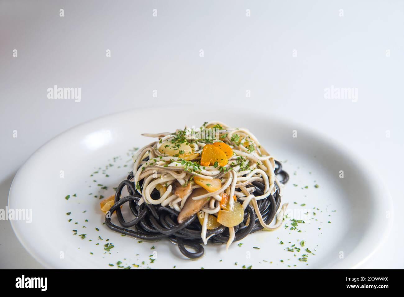 Black spaghetti with eels, garlic and parsley Stock Photo - Alamy