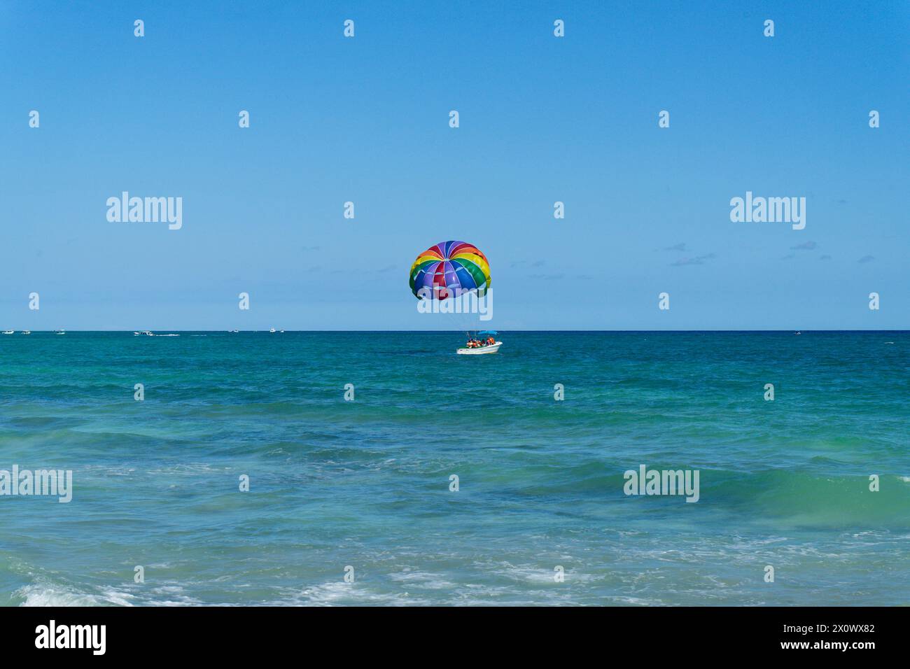 Colorful parasail on the serene blue Caribbean ocean, tied to the boat ...