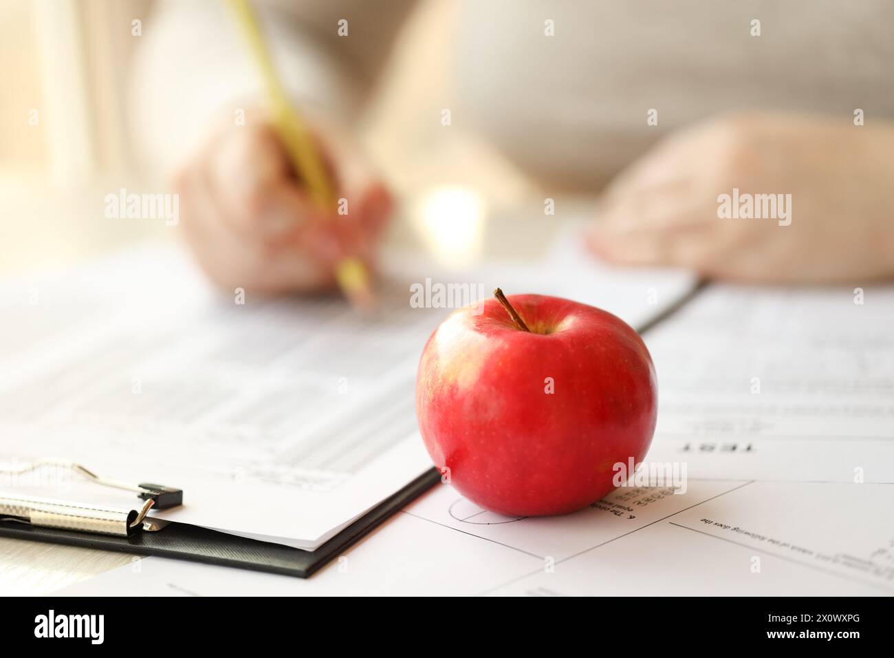 Female student hands testing in exercise and taking fill in exam paper ...