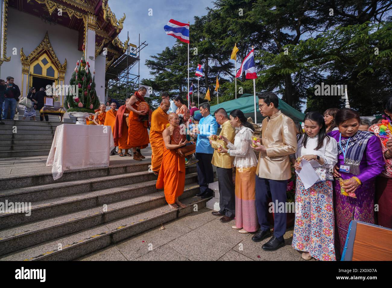 London 14 April 2024 .Thai Buddhists receive offerings from well ...