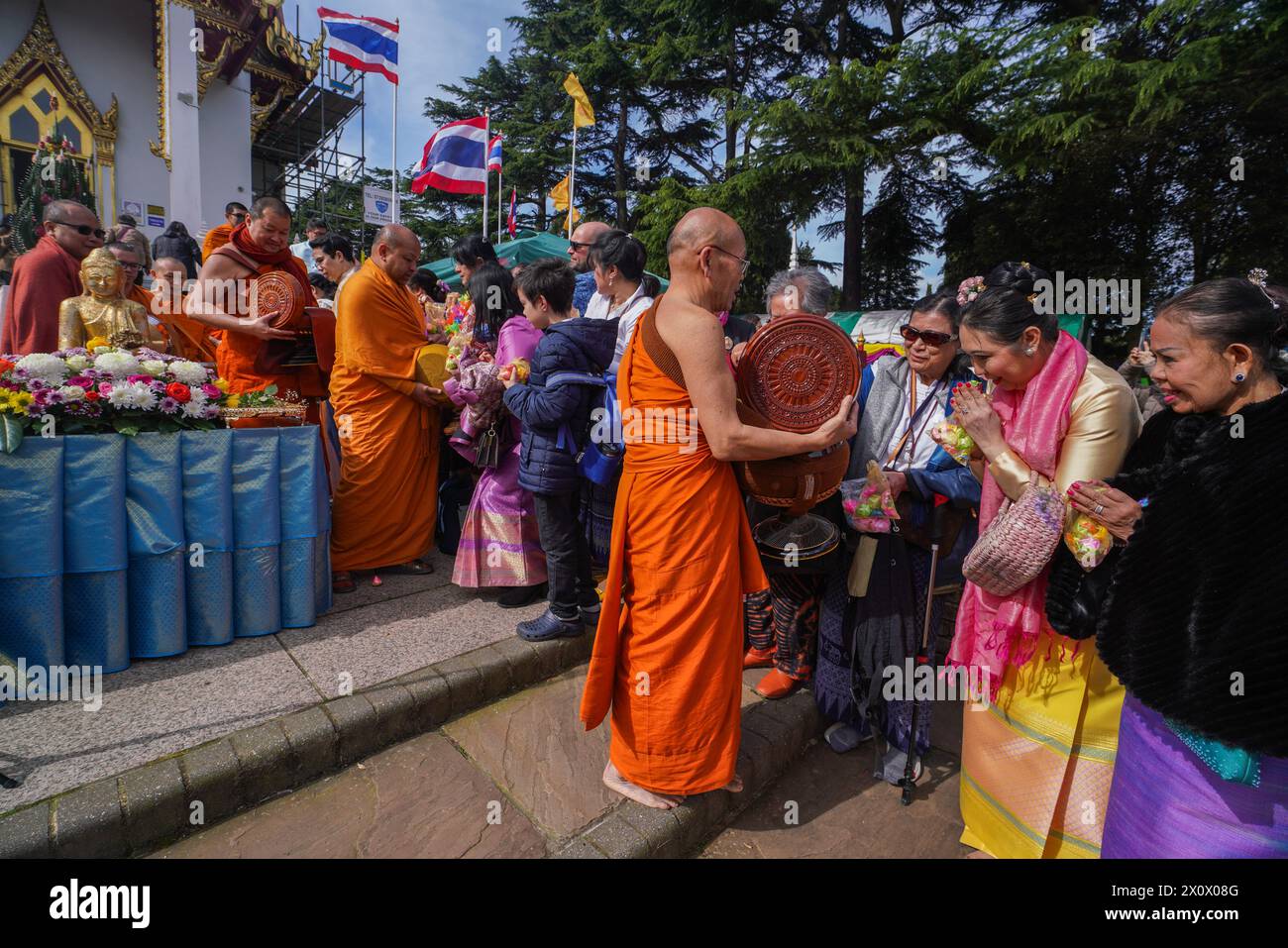London 14 April 2024 .Thai Buddhists receive offerings from well ...