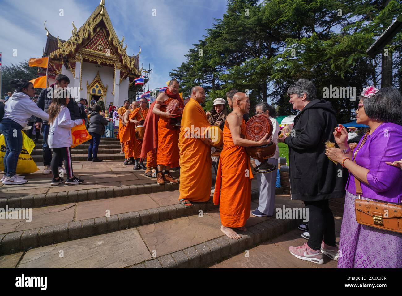 London 14 April 2024 .Thai Buddhists receive offerings from well ...