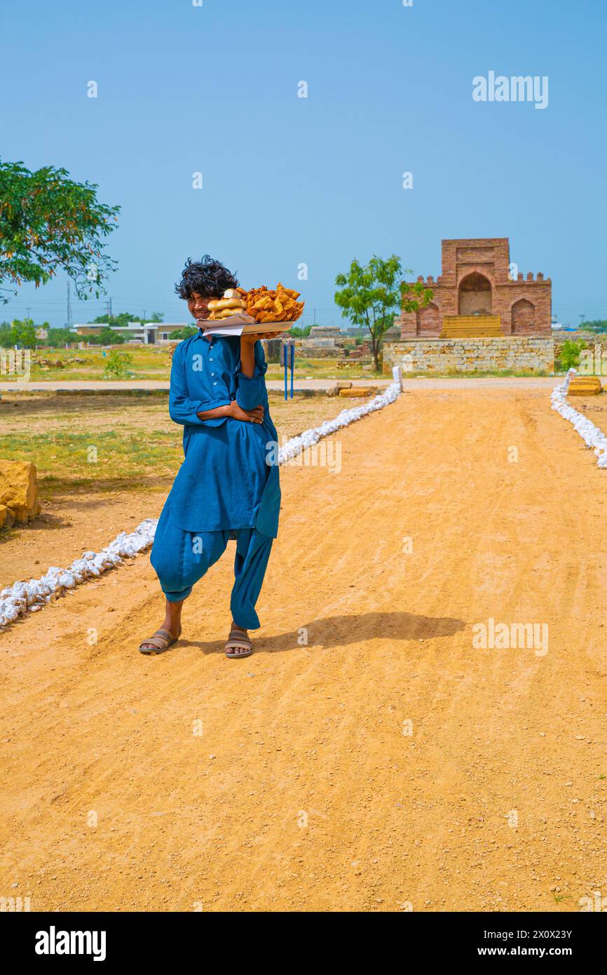 24 September 2023, Thatta, Pakistan. Younge man sells food in Makli ...