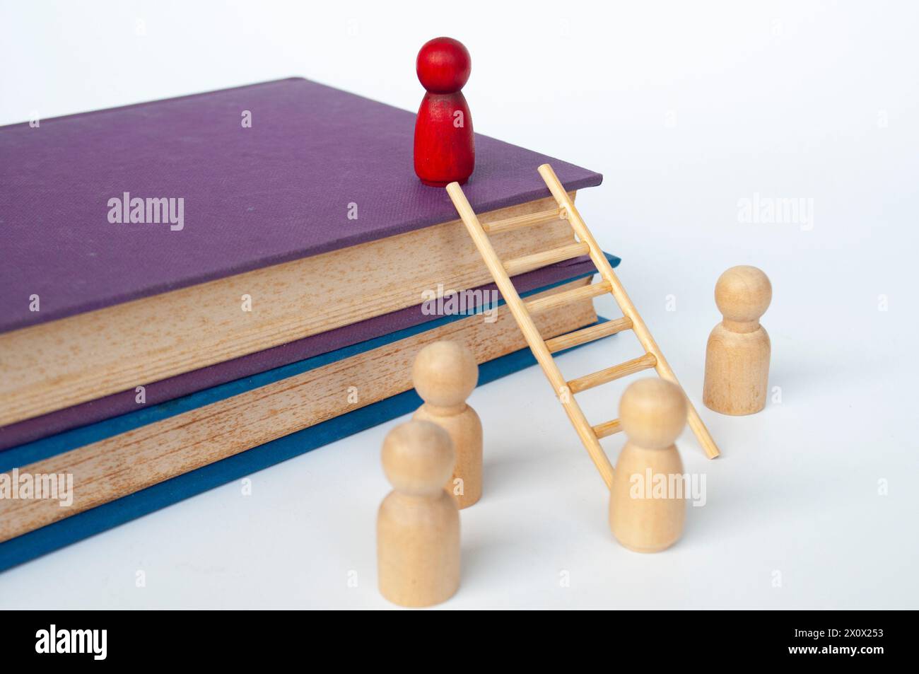 Ladder of success concept with books and doll figure climbing books ...