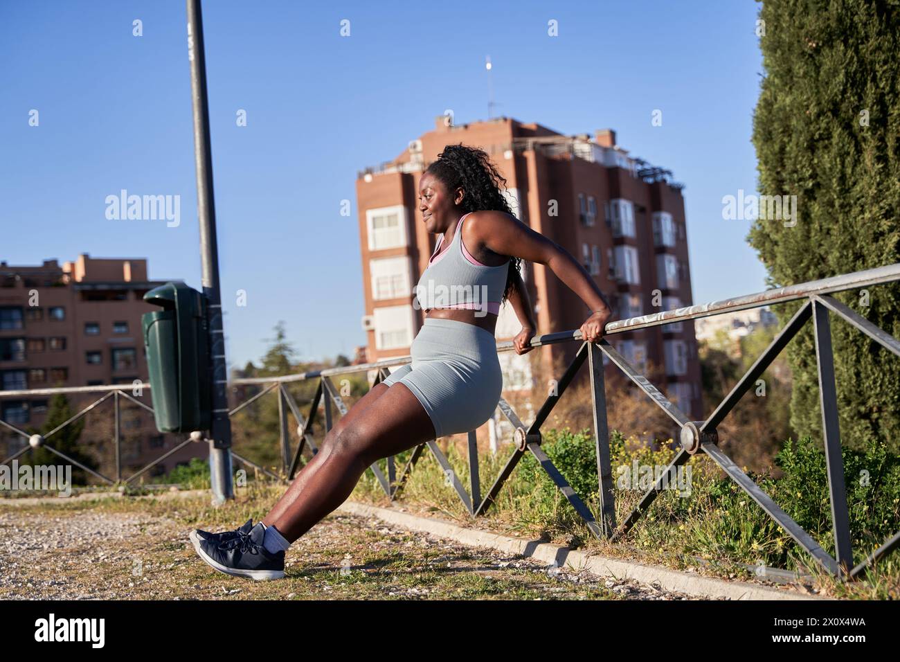African American woman doing triceps (dips) exercises on a railing in ...