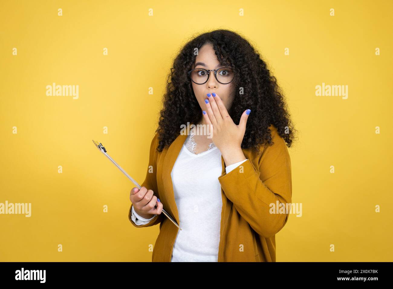 African american business woman with paperwork in hands over yellow ...