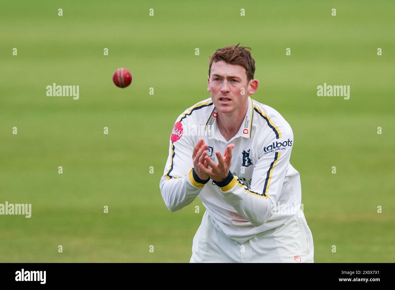Warwickshire's Rob Yates catches the ball returned to him as he limbers ...
