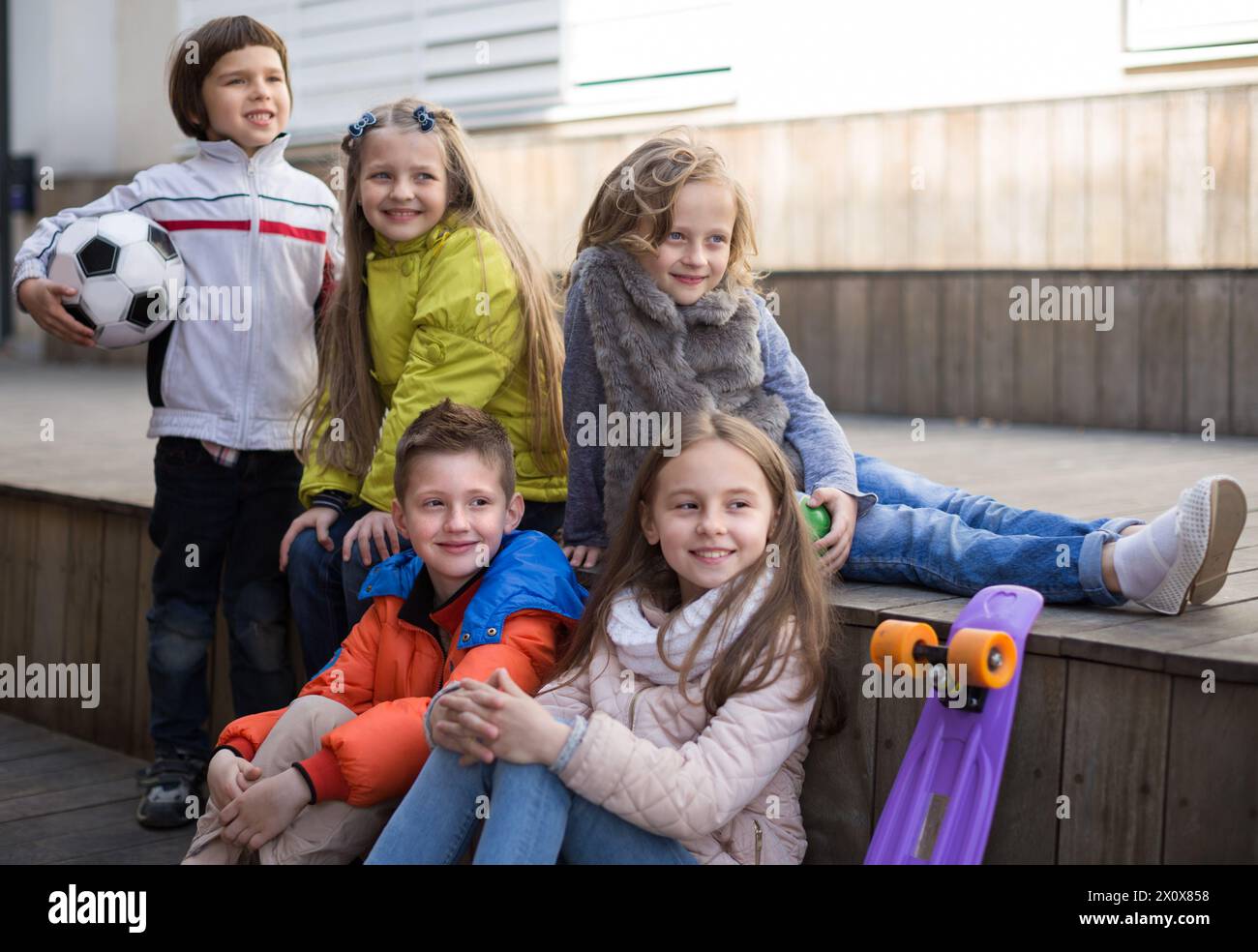 Group of children sitting on wooden scaffolding schoolyard Stock Photo ...